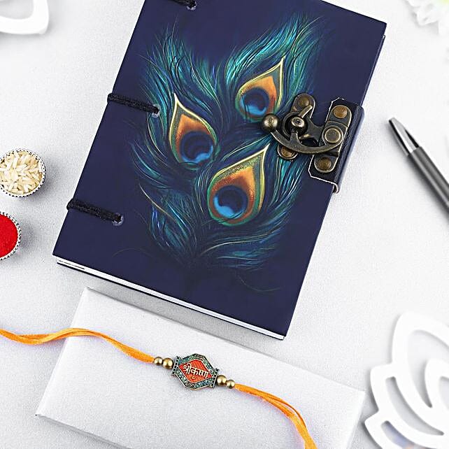Buy/Send Krishna Delight Rakhi & Peacock Feather Notebook Online- FNP